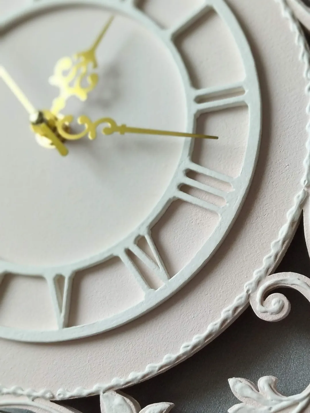 Small pink wall clock with white ornaments and roman numerals in ...